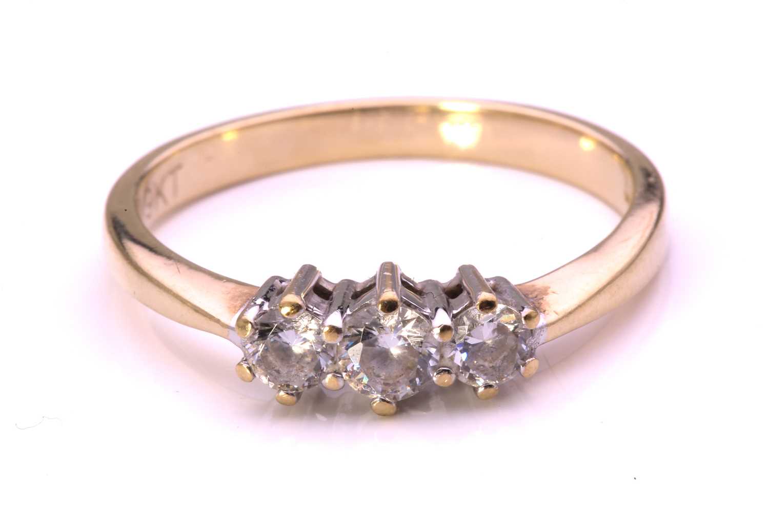 Lot 159 - A cubic zirconia trilogy ring in 9ct gold,