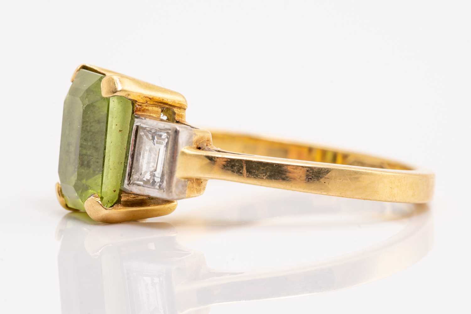 Lot 261 - A peridot and diamond trilogy ring in 18ct